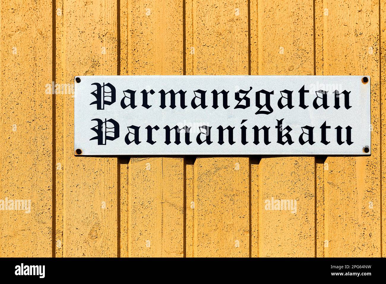 Bilingual street sign on yellow wooden facade, old wooden house, street ...