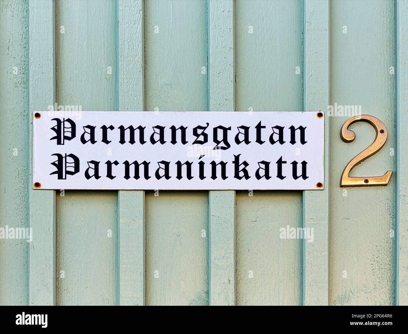 Bilingual street sign on wooden facade, wooden house, street name ...