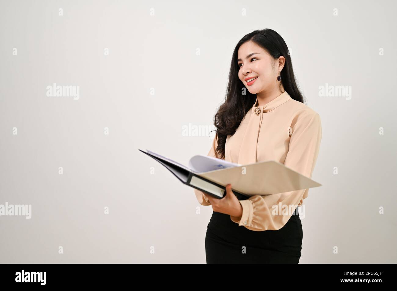 Professional and attractive millennial Asian female teacher holding a ...