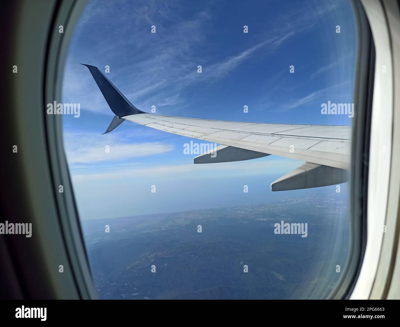 View through airplane window of commercial jet plane wing flying high ...