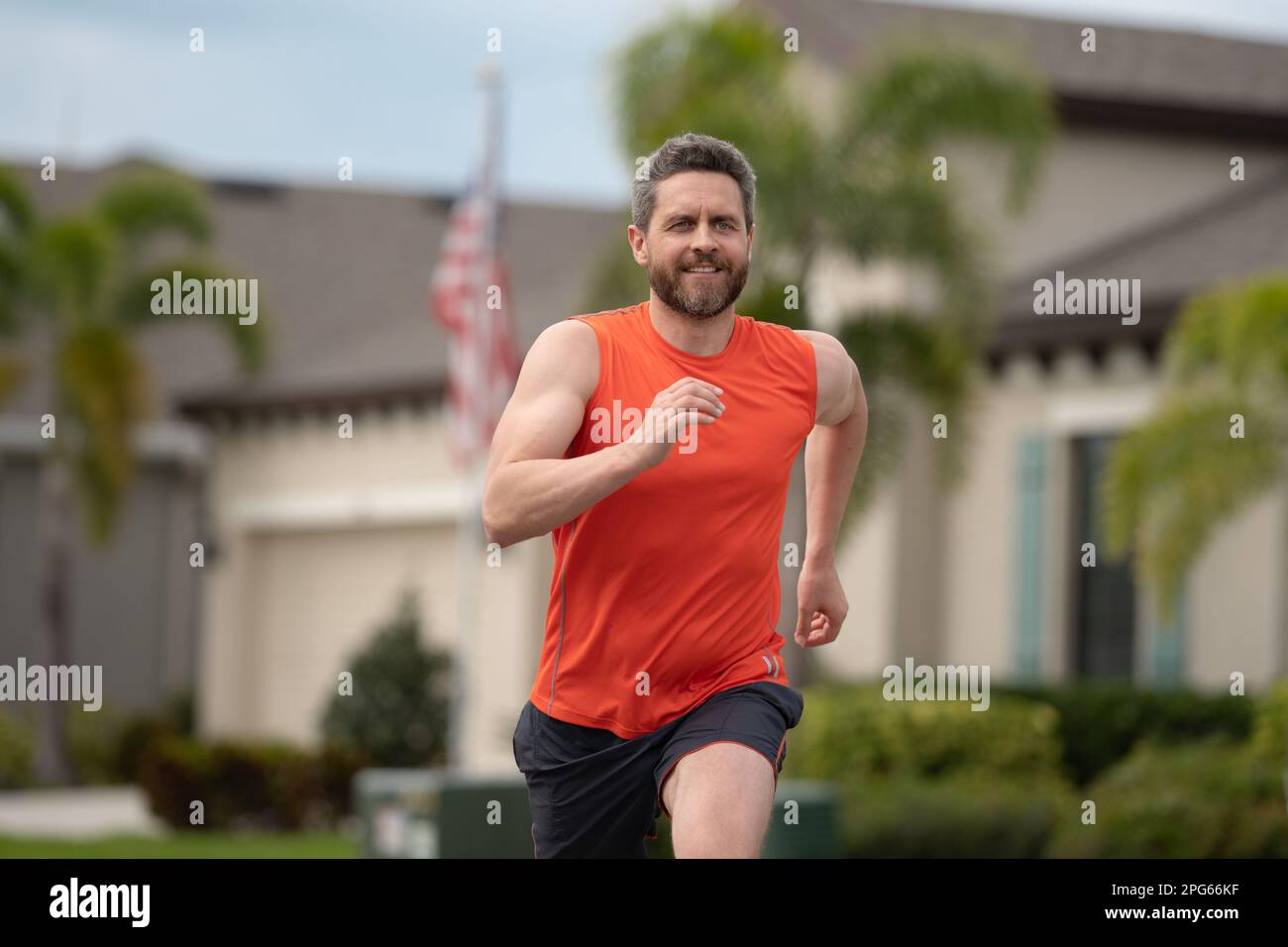 Handsome middle aged man running across american neighborhood. Athletic ...
