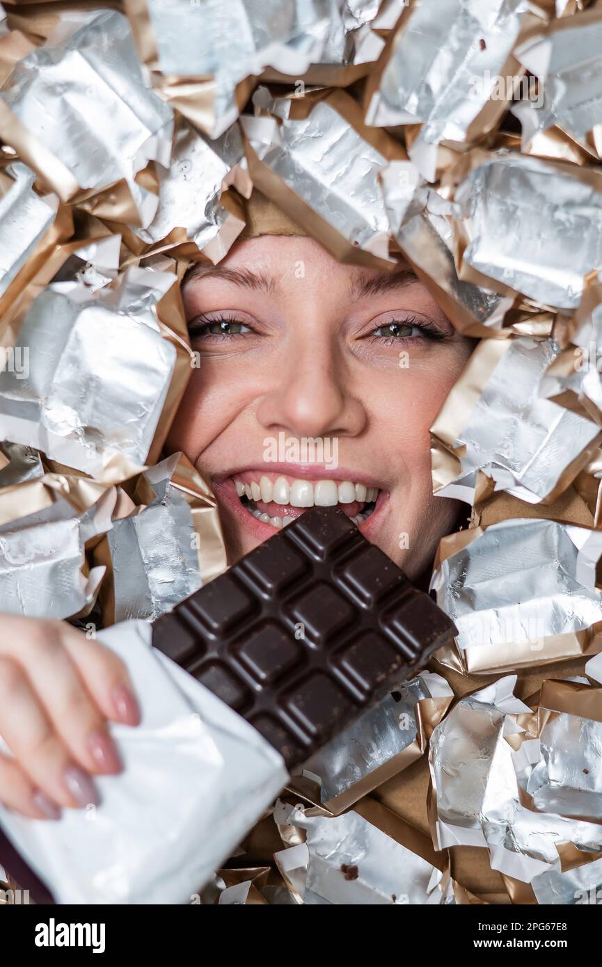 The face of a Caucasian woman surrounded by candy wrappers. The girl ...