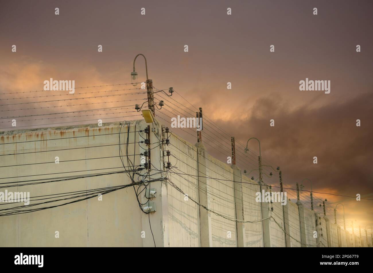 Prison security electric fence and high concrete wall. Prison high ...