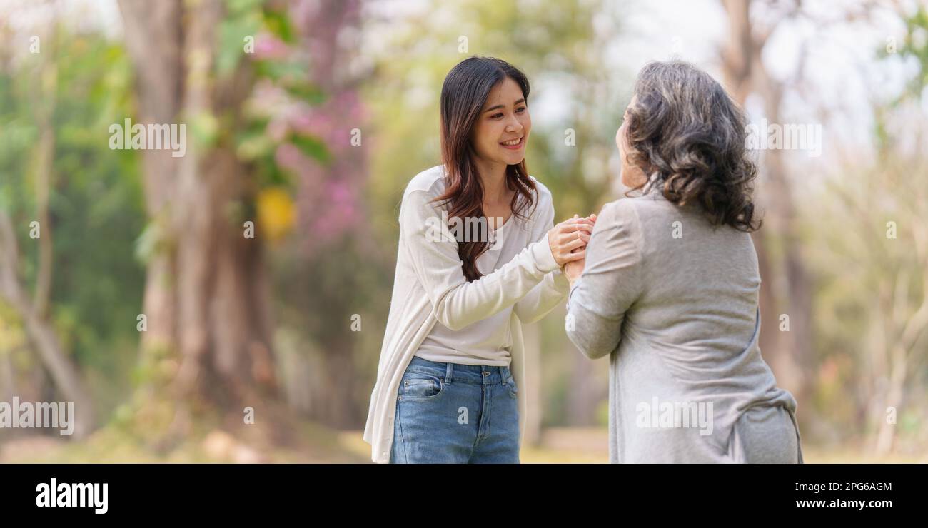 Close up of Adult daughter holding her elderly mother hand with love ...