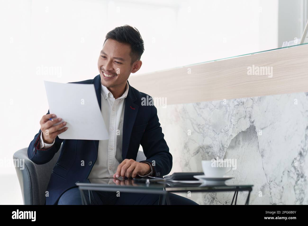 Smiling Asian Banker makes financial report and studies annual figures ...