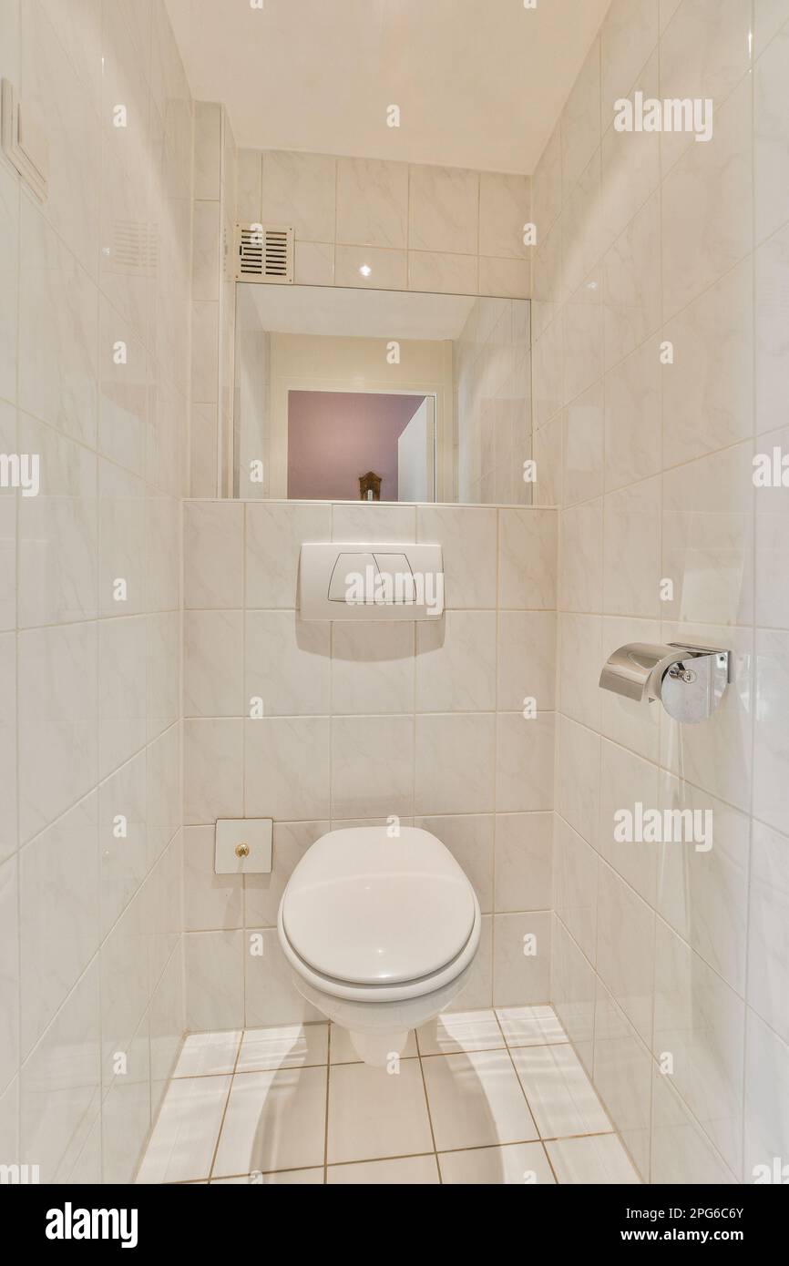 a white toilet in a bathroom with tile flooring and wall mounted mirror ...
