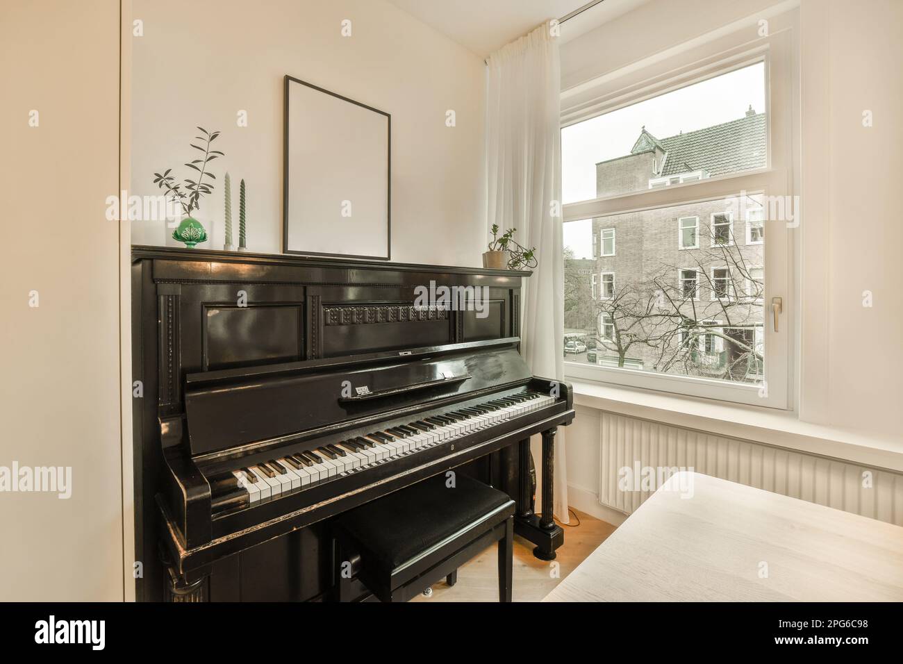a piano in the corner of a room with a large window looking out onto an ...
