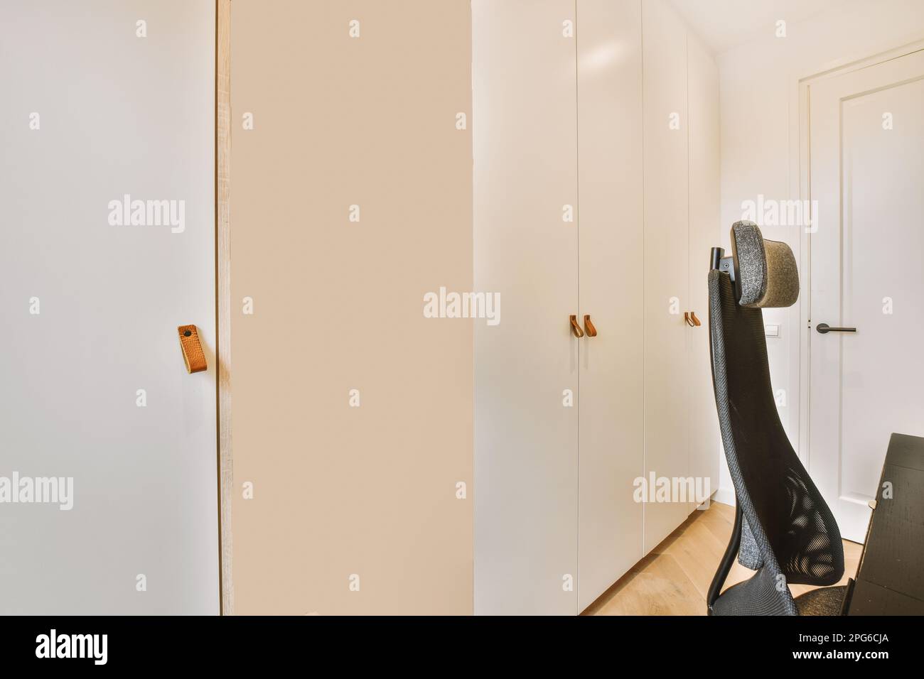 a chair in the corner of a room with white walls and wood flooring on ...