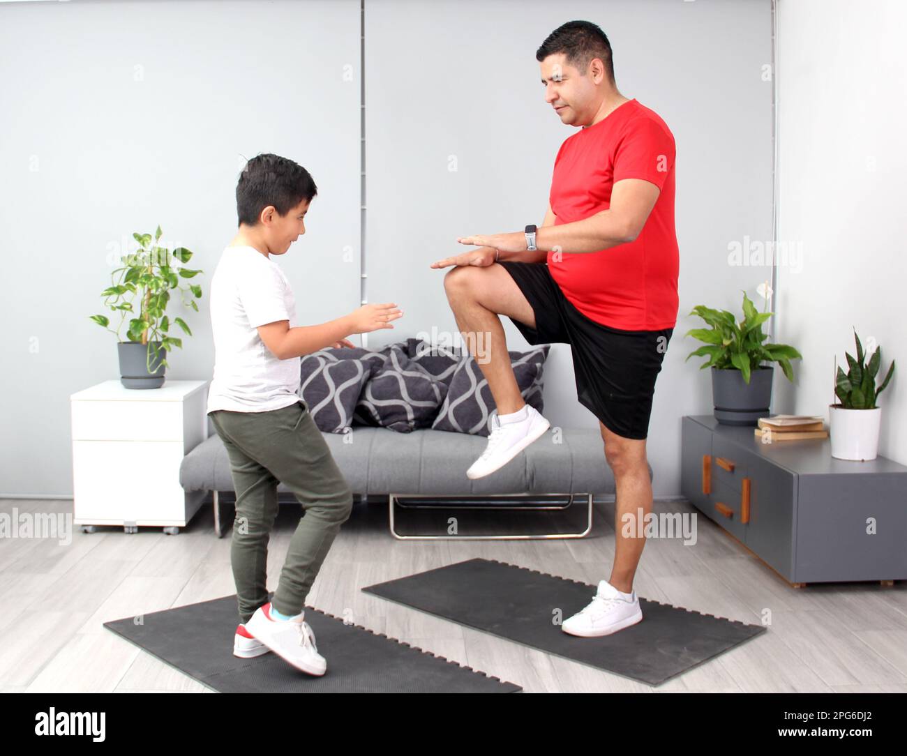 Overweight Latino dad and son exercise at home to lose weight and be healthy to avoid diseases ...