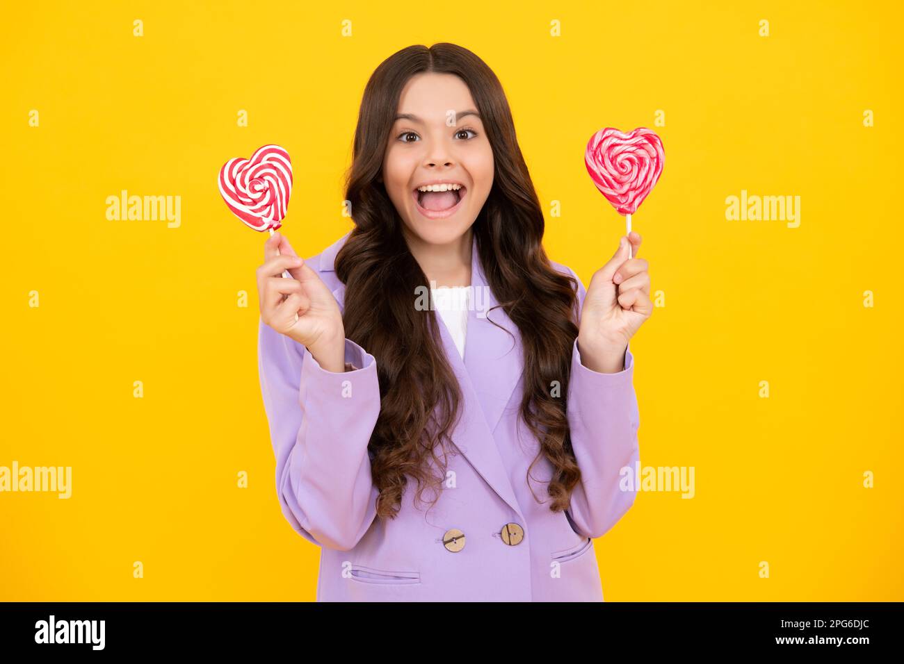 Cool teen child with lollipop over yellow isolated background. Sweet ...