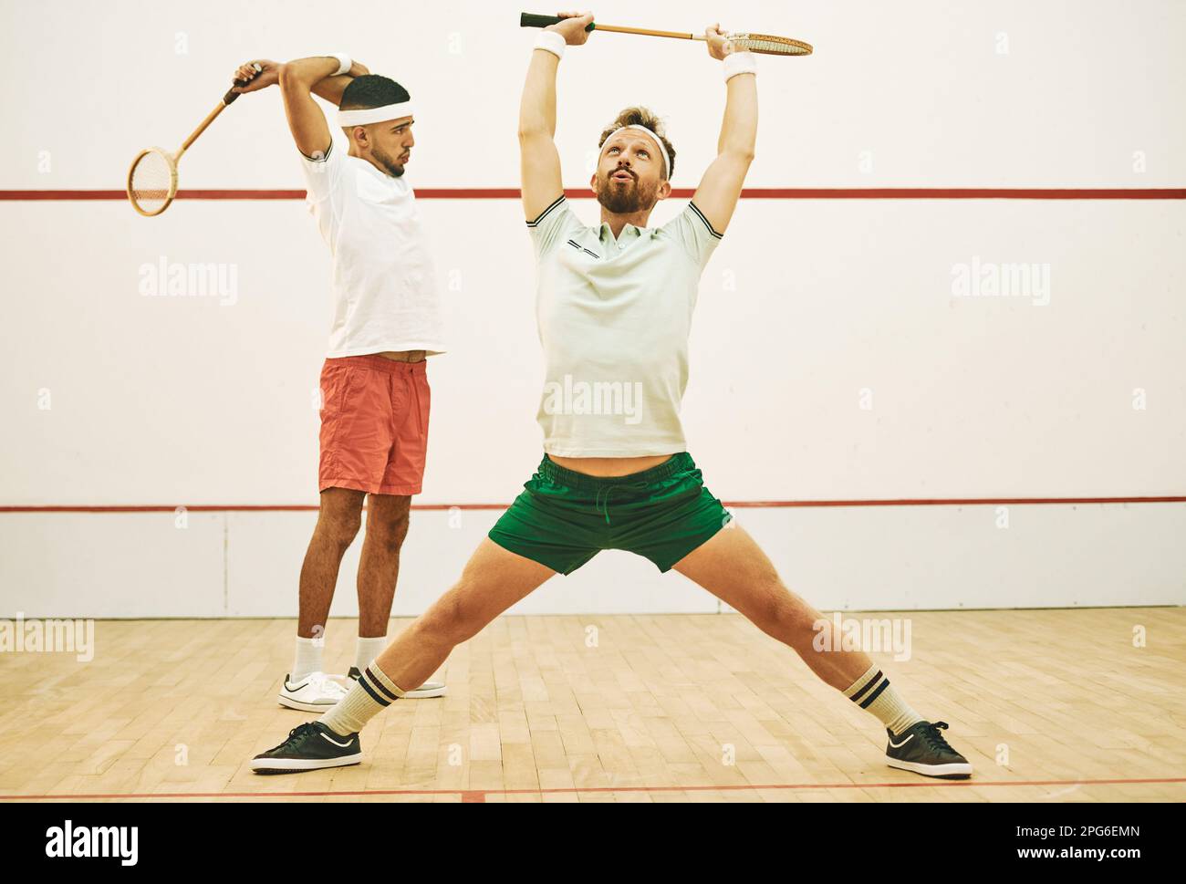Reduce the risk of injury with a warmup. two young men stretching ...