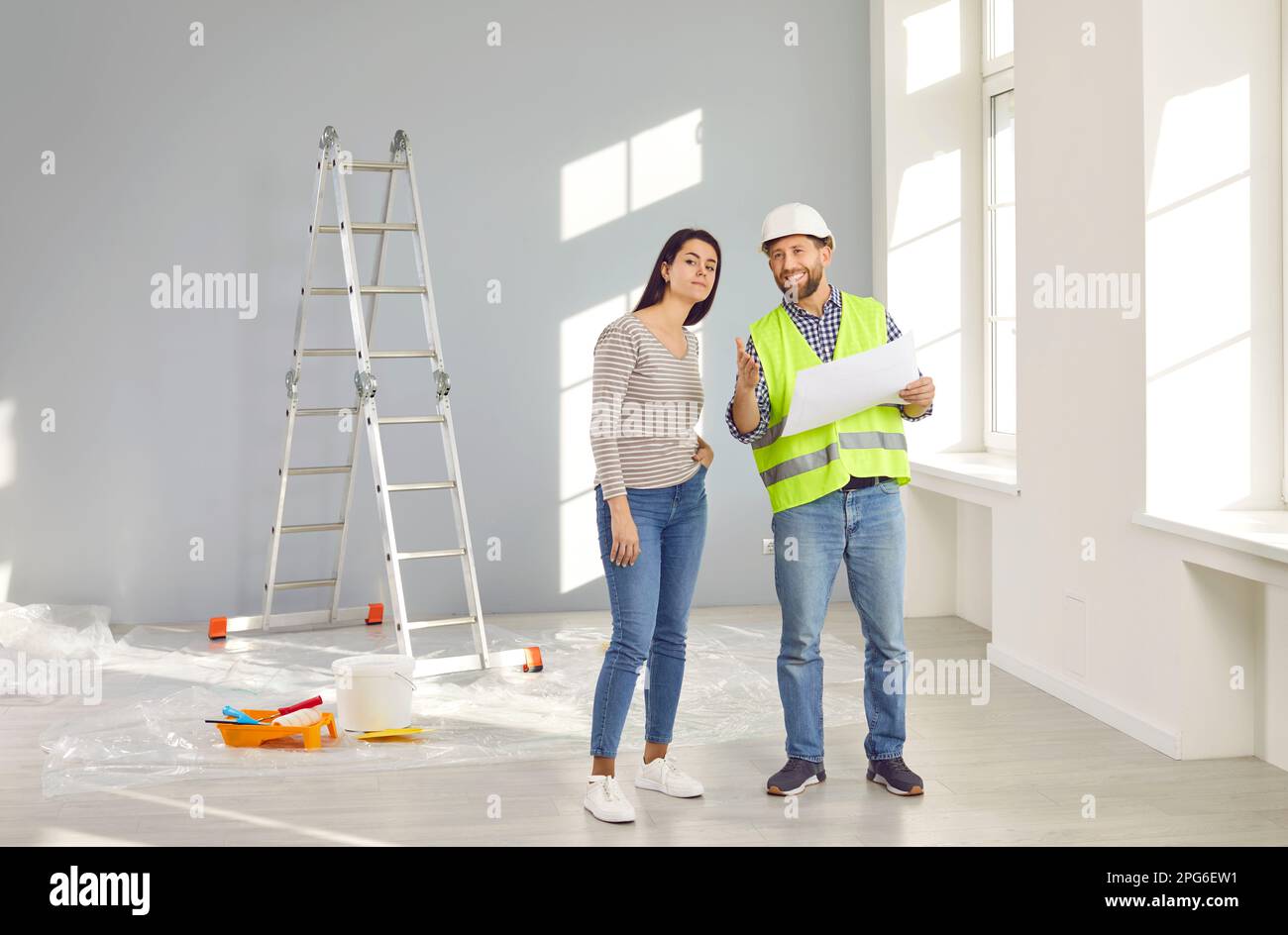 Builder, repairman showing house design plan to apartment owner Stock ...