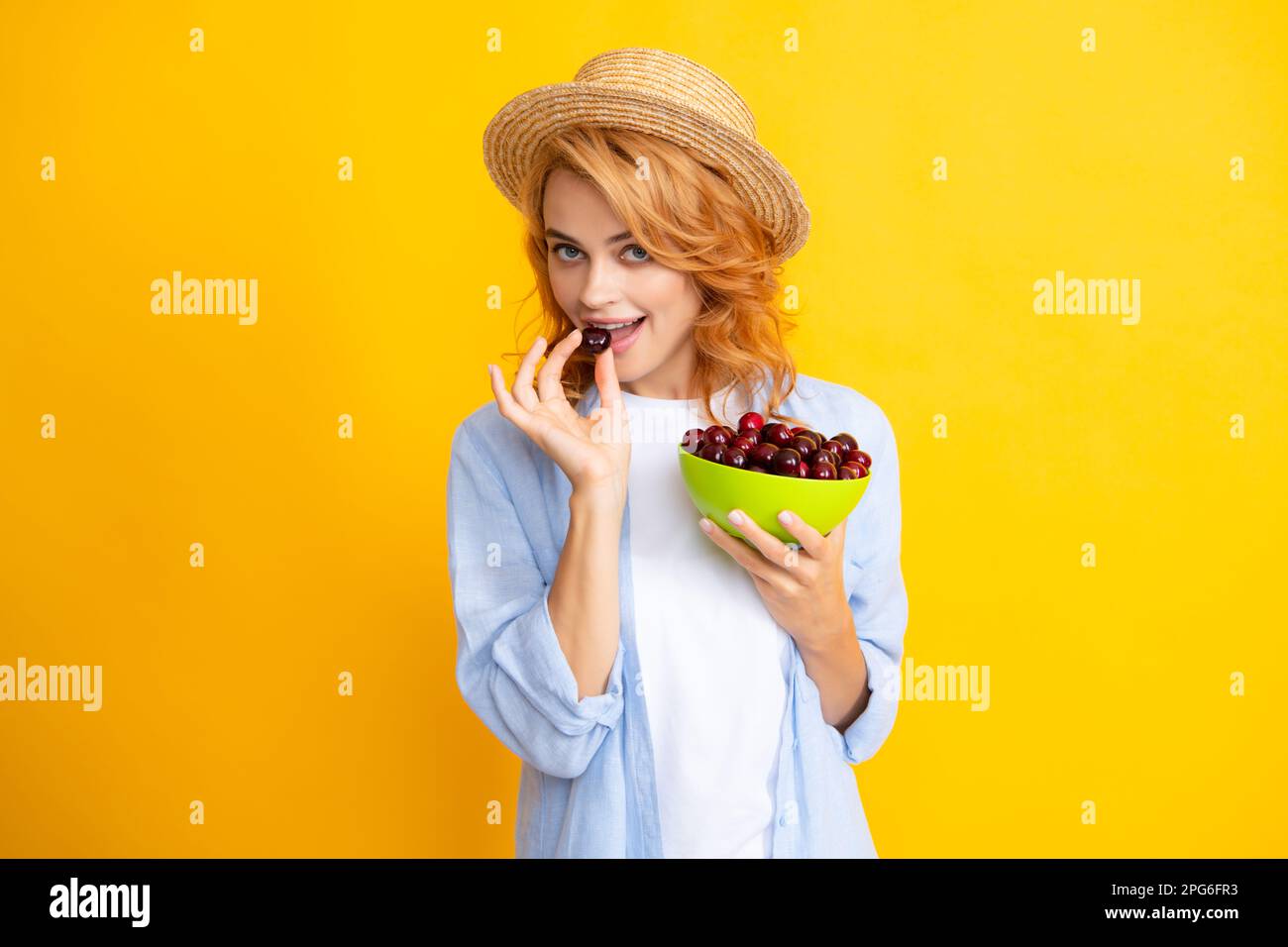 Attractive young woman eating fresh cherry. Healthy summer fruits ...