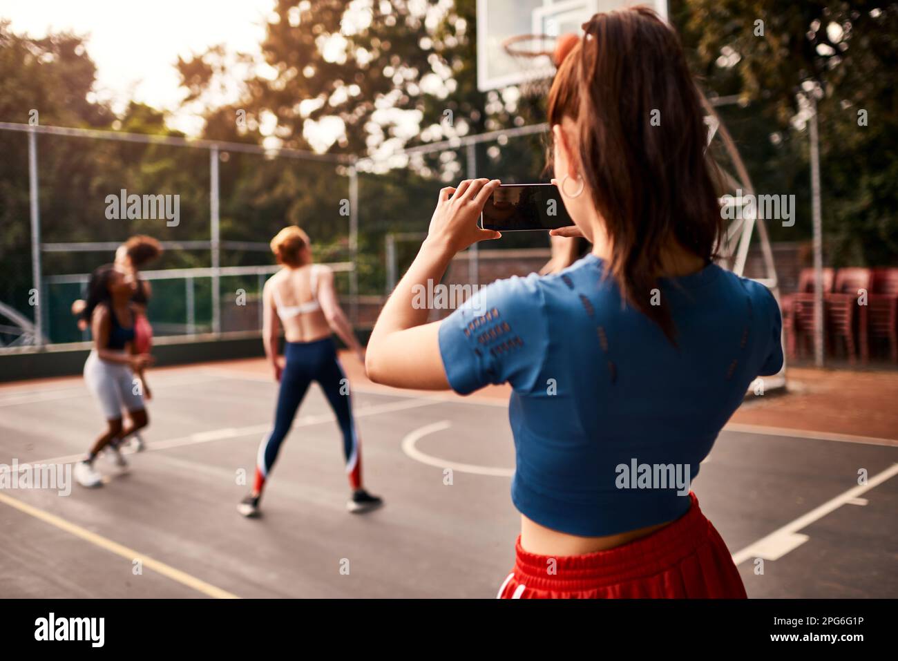 Filming the game for feedback later. an unrecognizable sportswoman ...