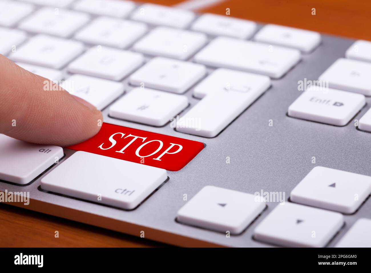 Finger pushing red stop button on modern keyboard. Danger and web ...