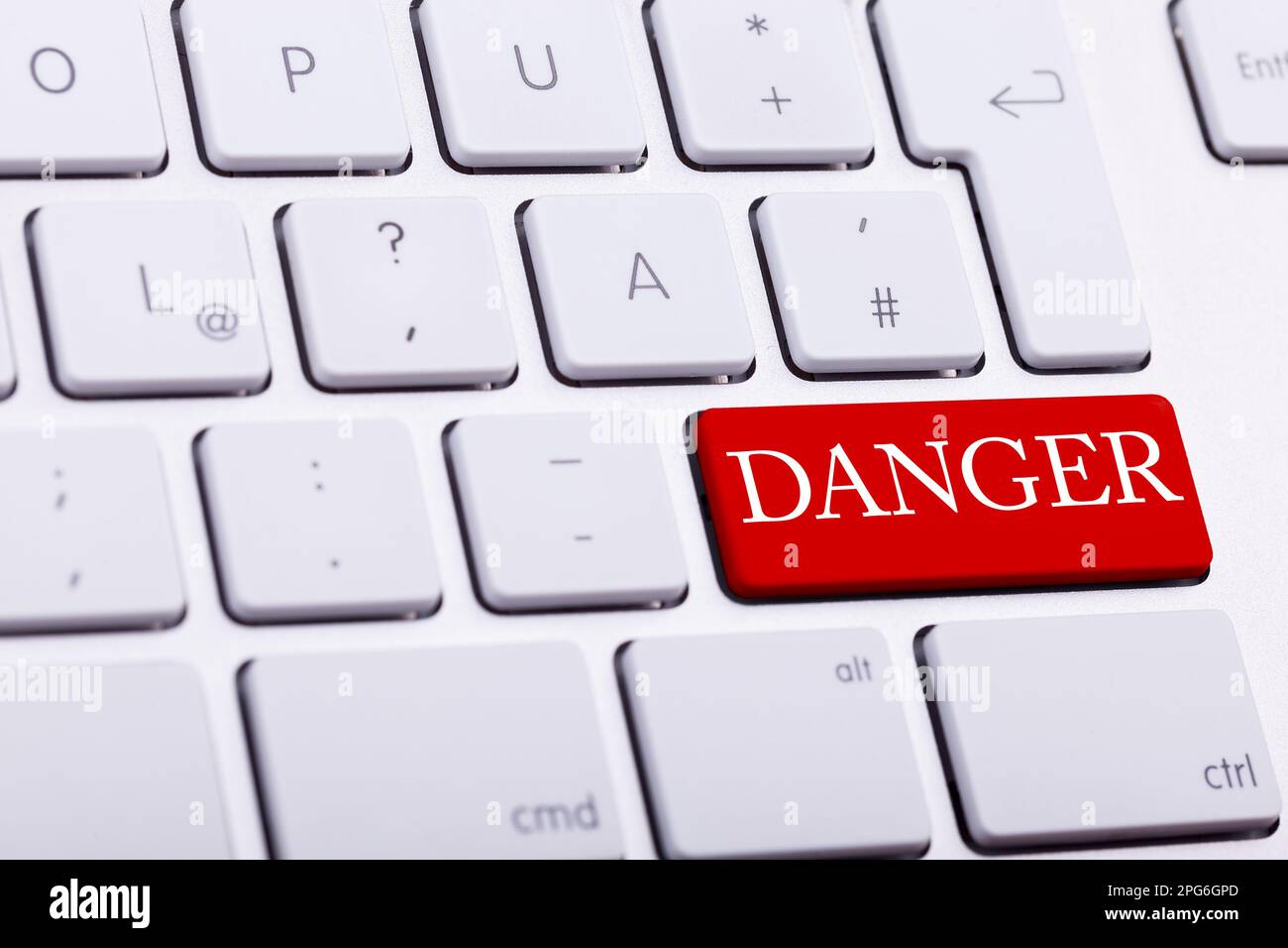 Alluminium keyboard with DANGER word written on red button close up ...