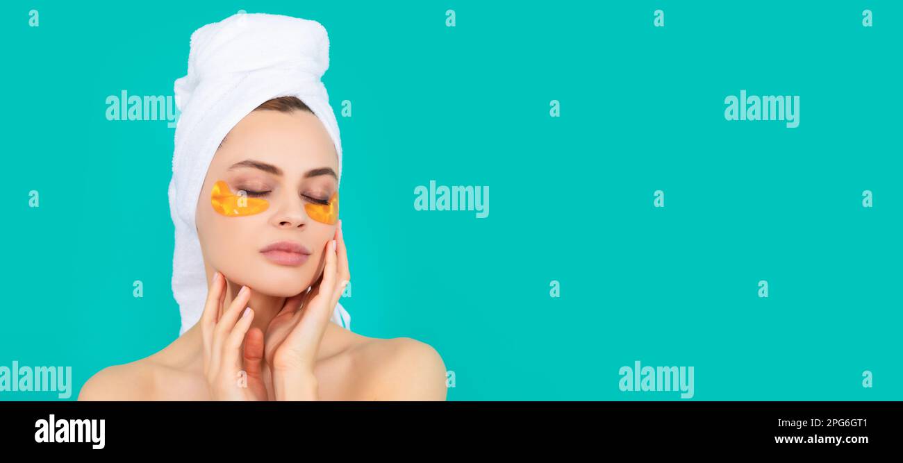 lady has collagen golden eye patches on face with towel. Beautiful woman isolated face portrait ...