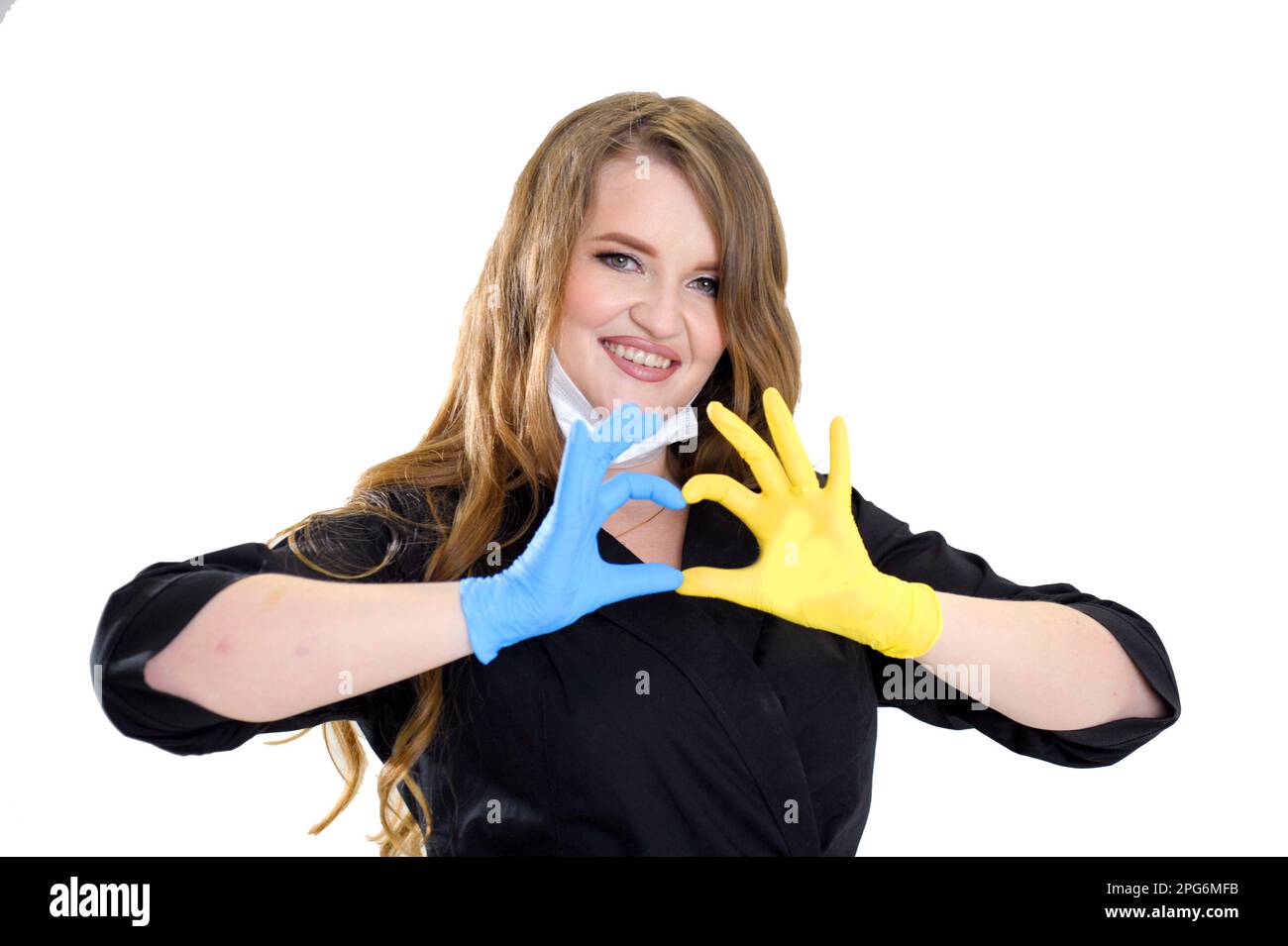 female doctor in a mask makes a heart shape with her hands yellow and ...