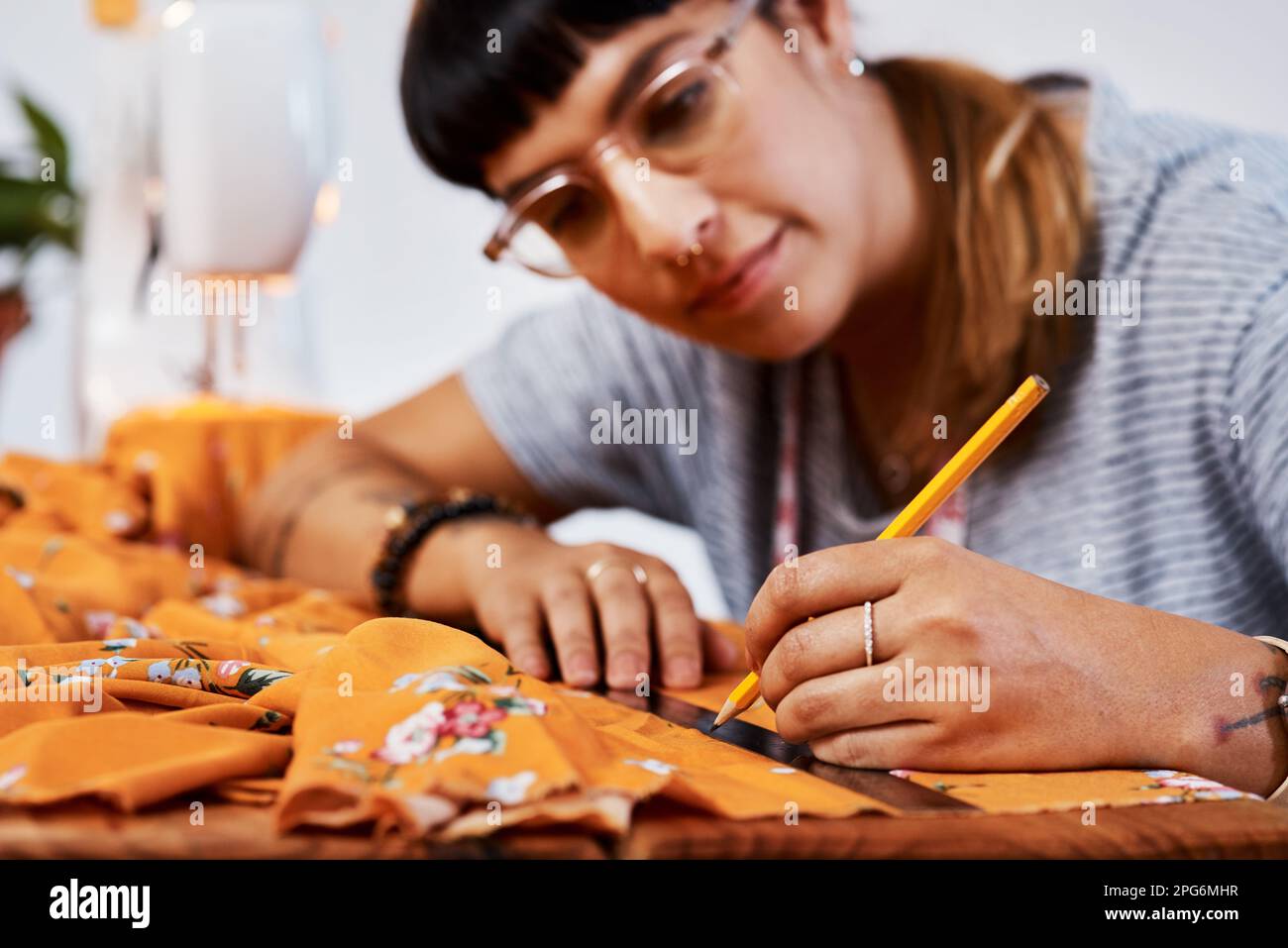 I can cut the rest off. an unrecognizable woman making a garment at ...