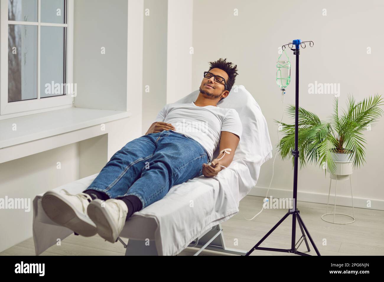 Male patient lying on bed during intravenous injection in medical ...