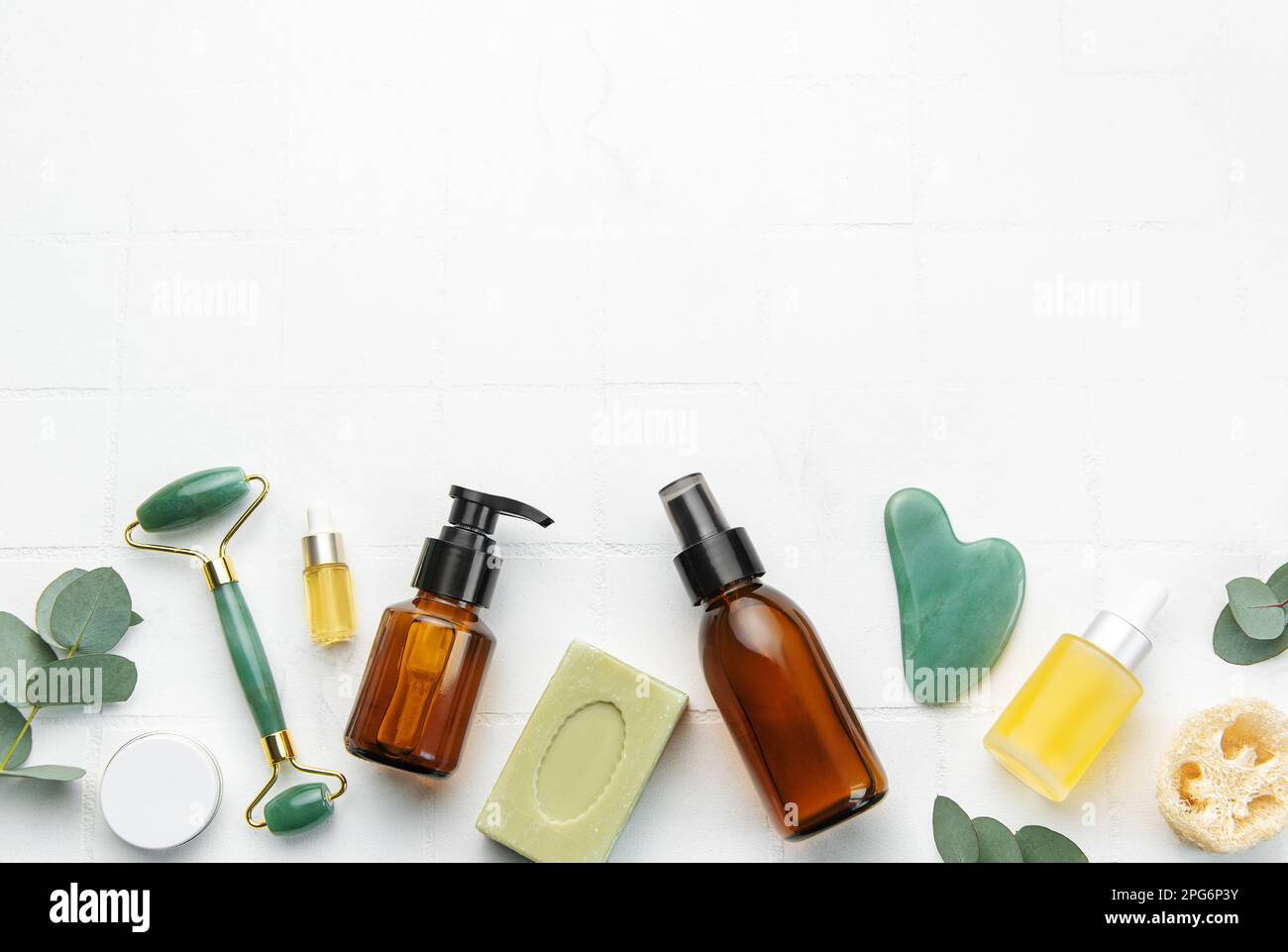 Soap, eucalyptus, aroma oil, spa objects on white tile background. Top ...