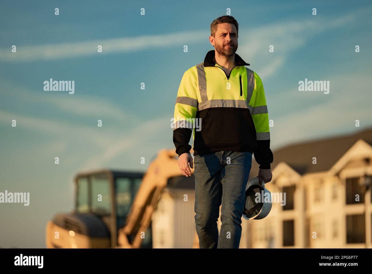Builder in a construction site. Builder with excavator ready to build ...