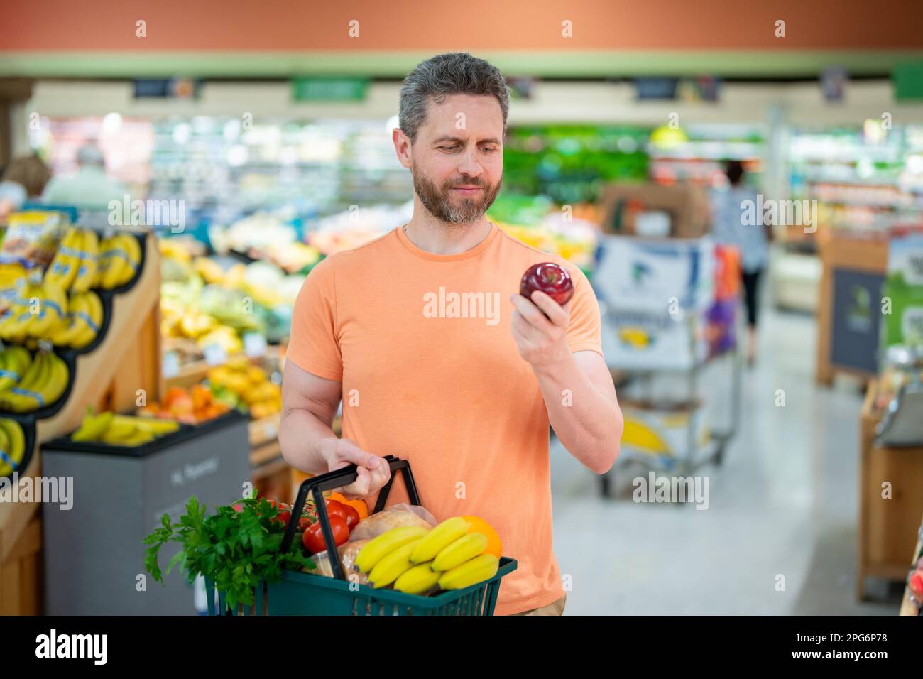 Portrait of man with shopping cart full of fresh vegetables in a food ...