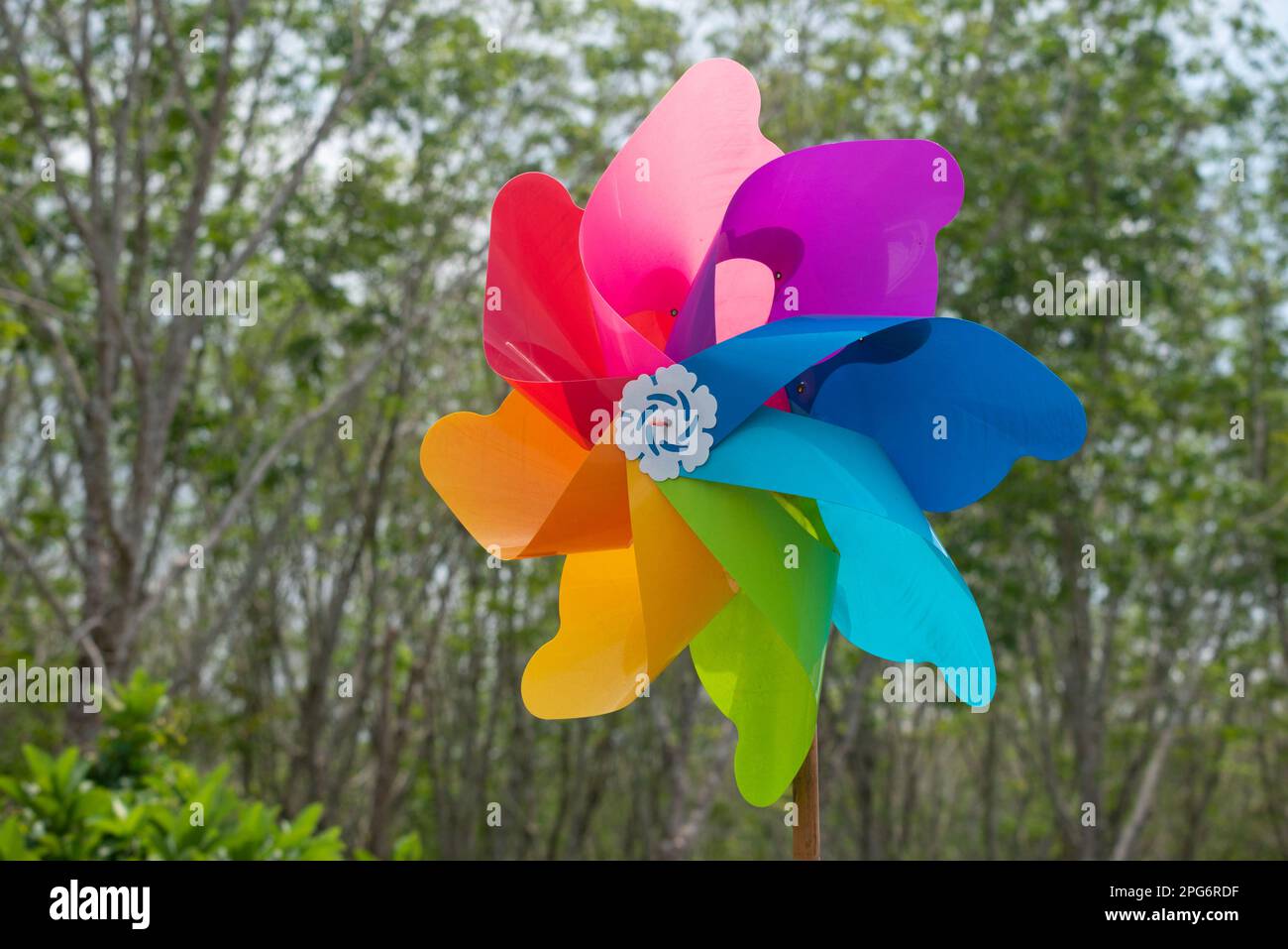 Colorful multicolored plastic wind turbine on trees background Stock ...