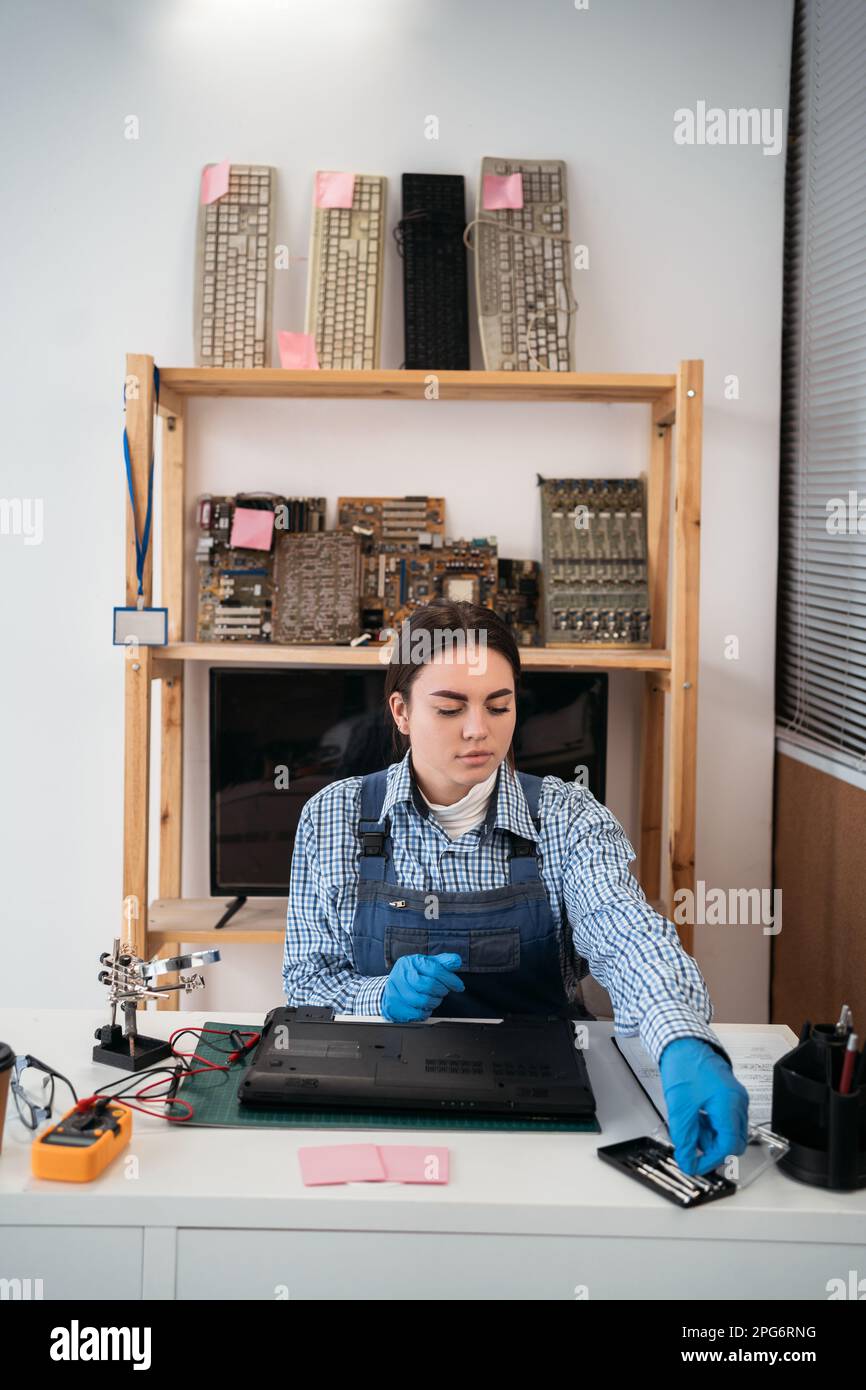 Laptop disassembling with screwdriver at repair shop. Laptop repair. Disassemble computer Stock ...