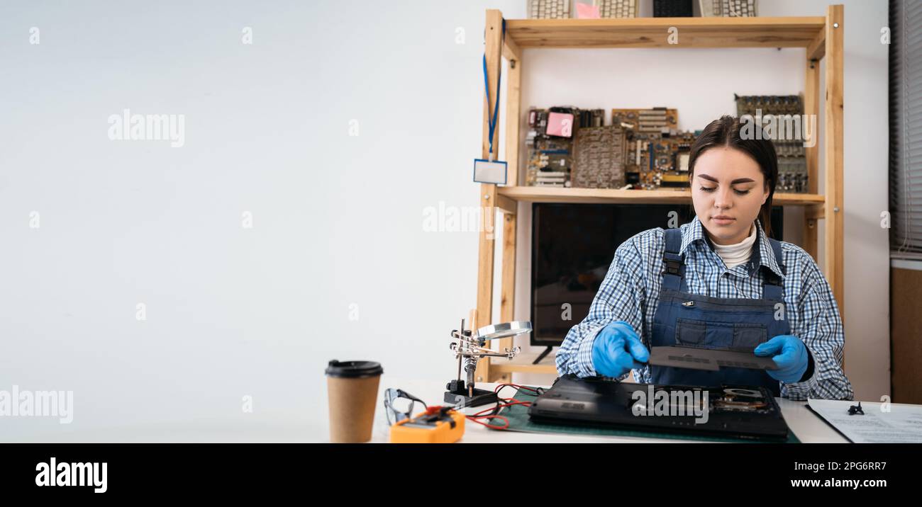 Laptop disassembling at electronic repair shop or workshop. Woman ...