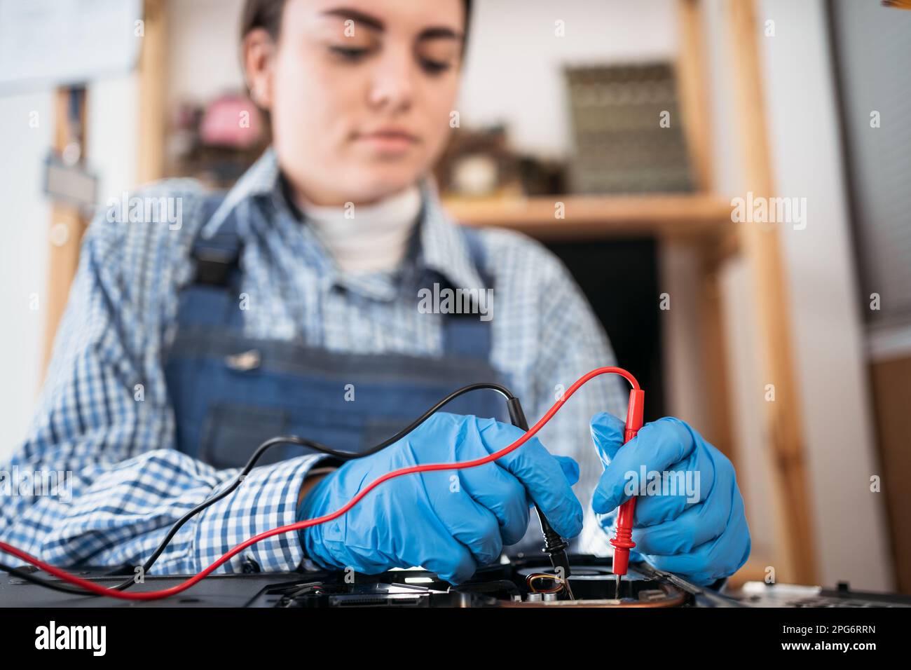 Repairman testing laptop motherboard using multimeter working in ...