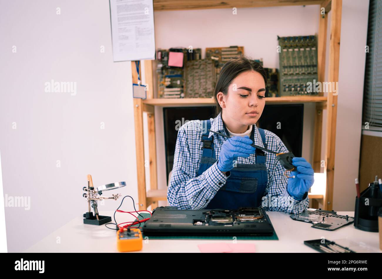 Female repairman working in technical support fixing computer laptop ...