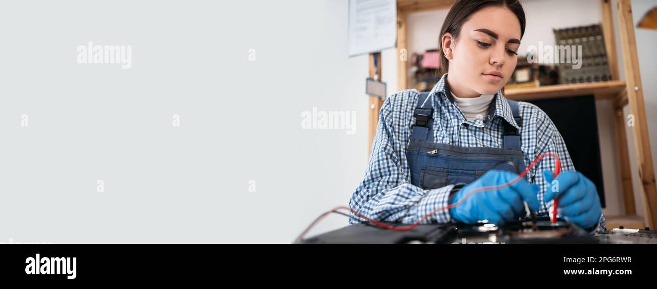 Technician woman repairing a laptop in the service center. Concept of ...