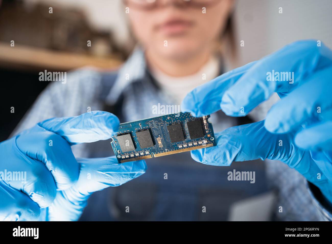 Service technician with memory on a computer motherboard. RAM in hand ...