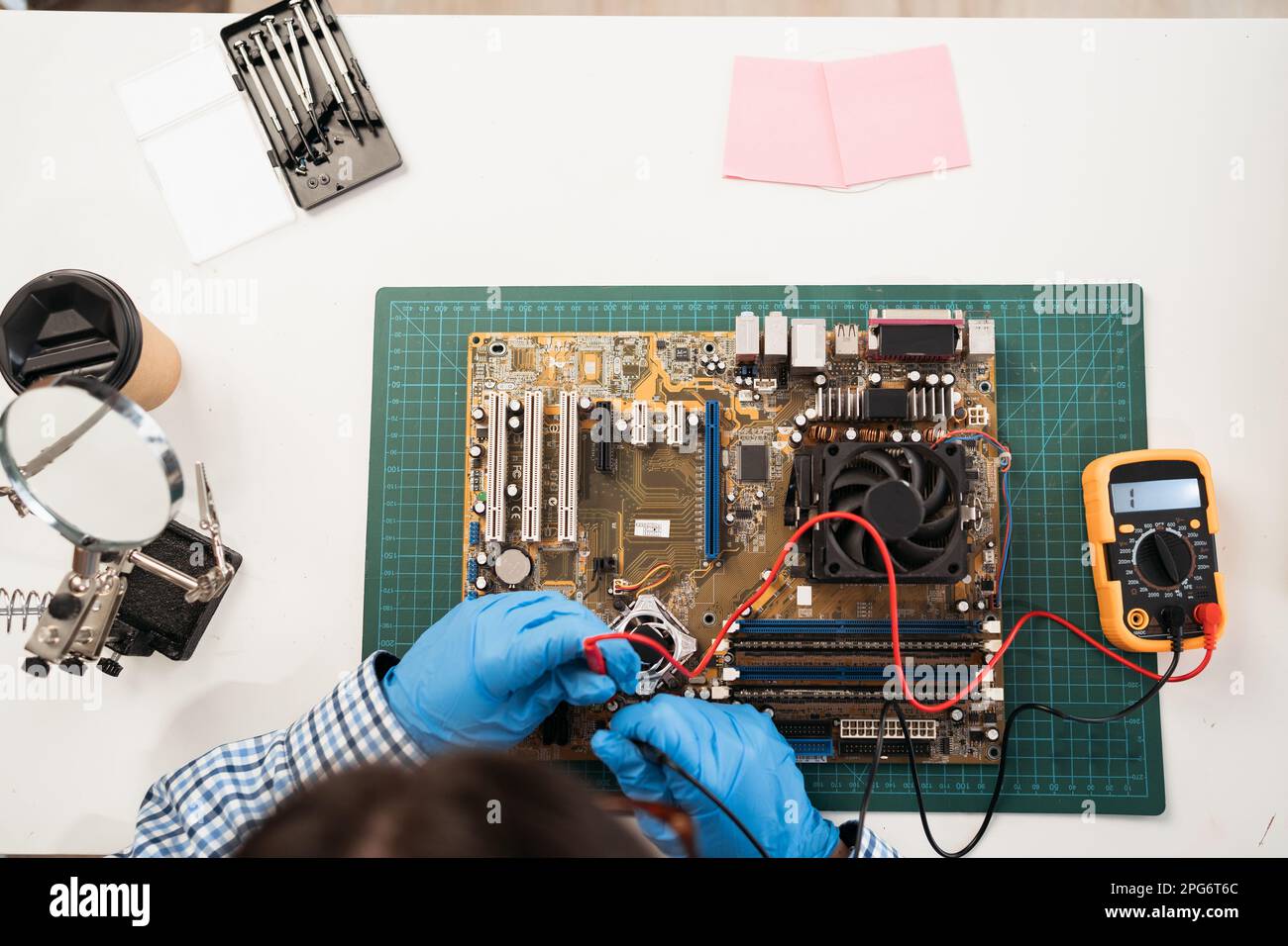 Computer engineer working on an old motherboard, testing it with ...