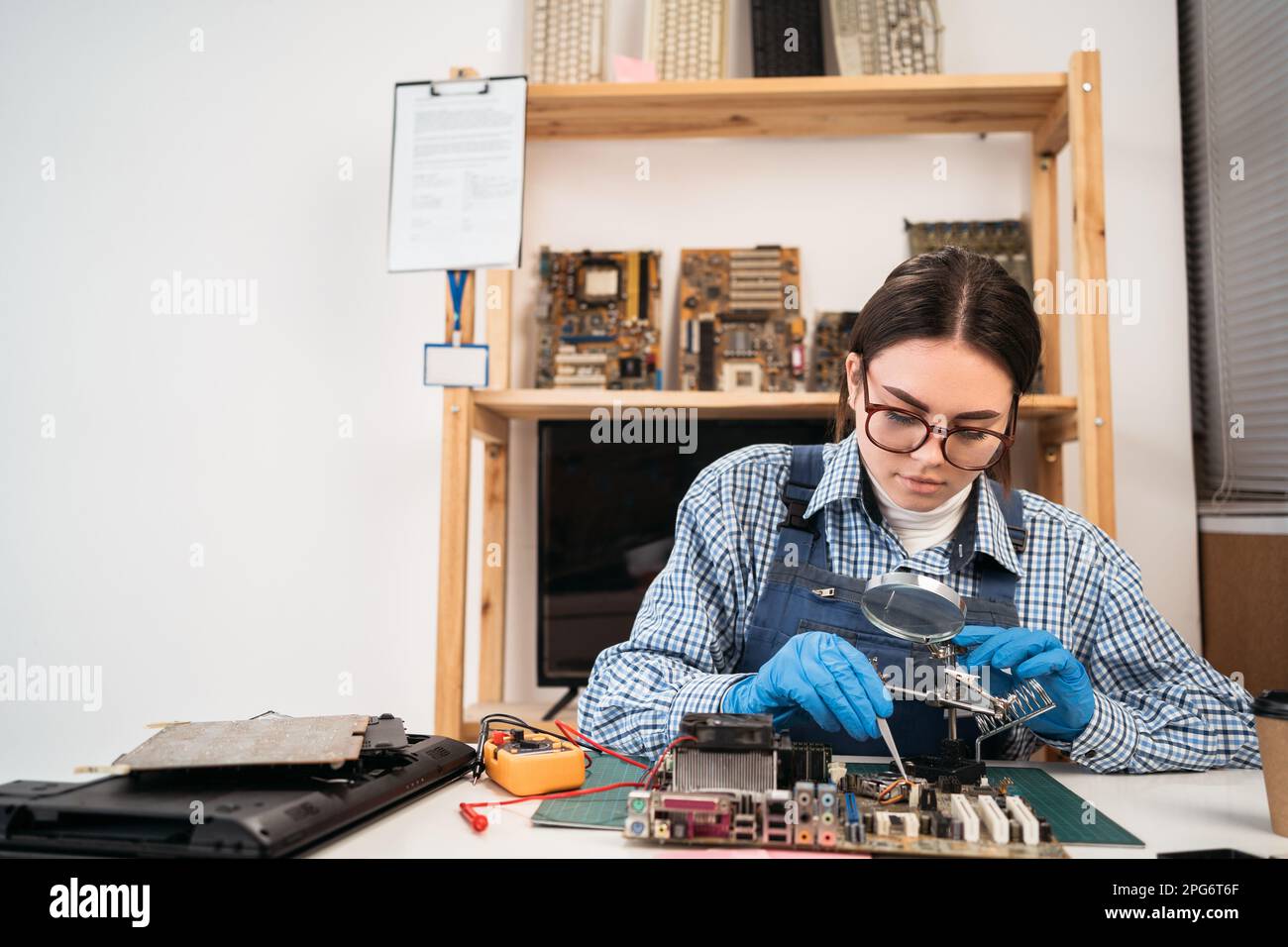 Engineer fixing broken computer motherboard using tweezers. Electronic ...