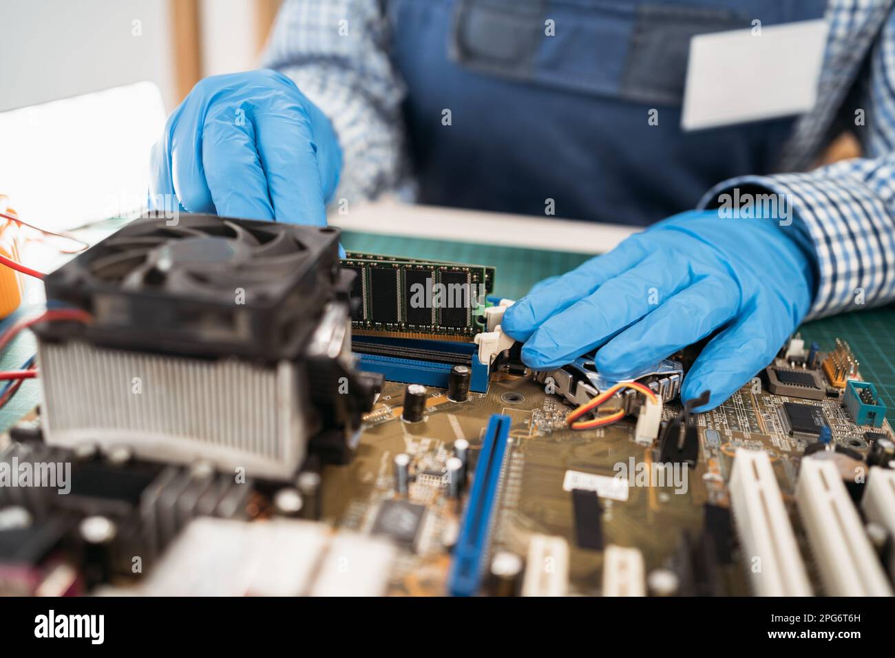 Installing random access memory into PC. Computer service engineer technician workplace ...