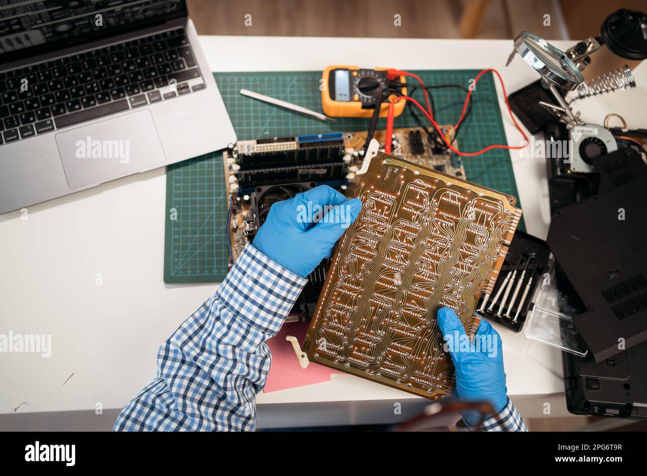 Female hands repairing computer details and using laptop on the table ...