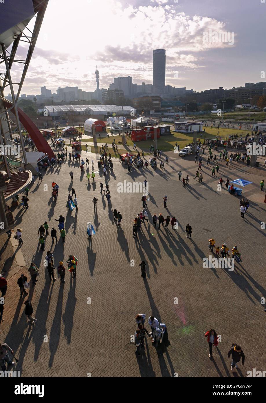 Sports enthusiasts and their shadows on a paved area outside Ellis Park ...