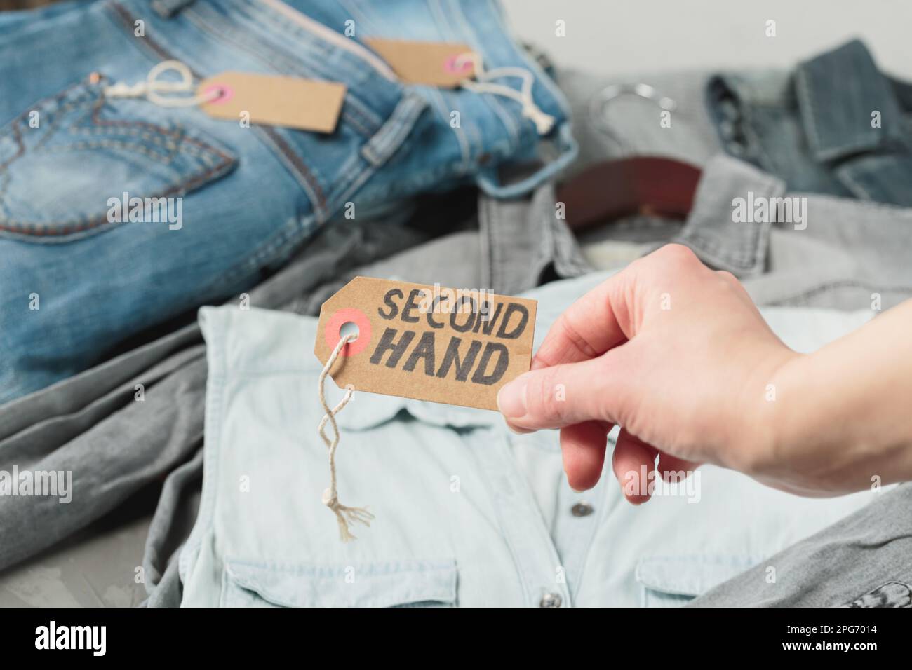 Womans hand holding tag with inscription second hand in store Stock ...