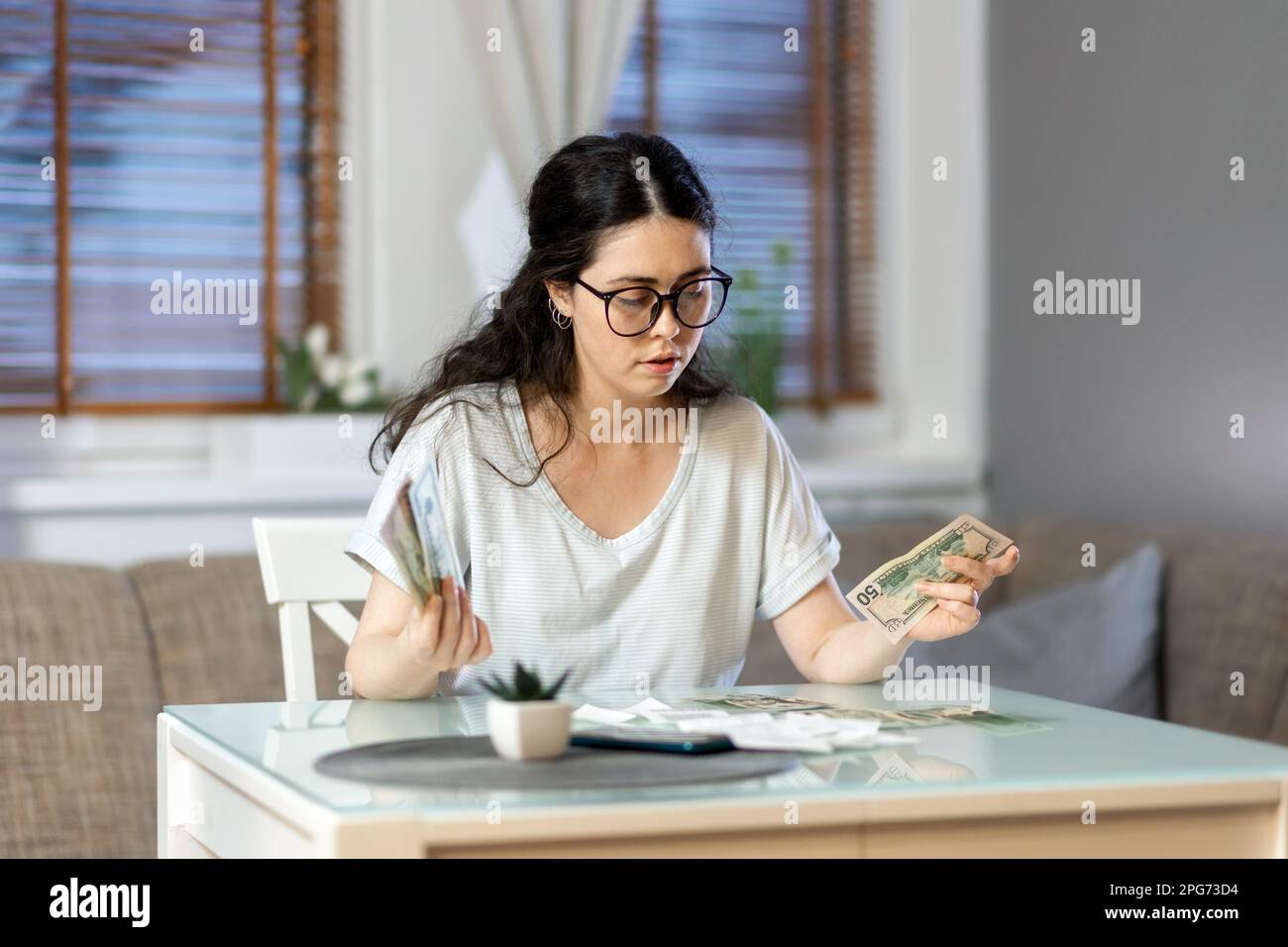 Planning of expenses. Portrait of caucasian young woman accounting cash ...