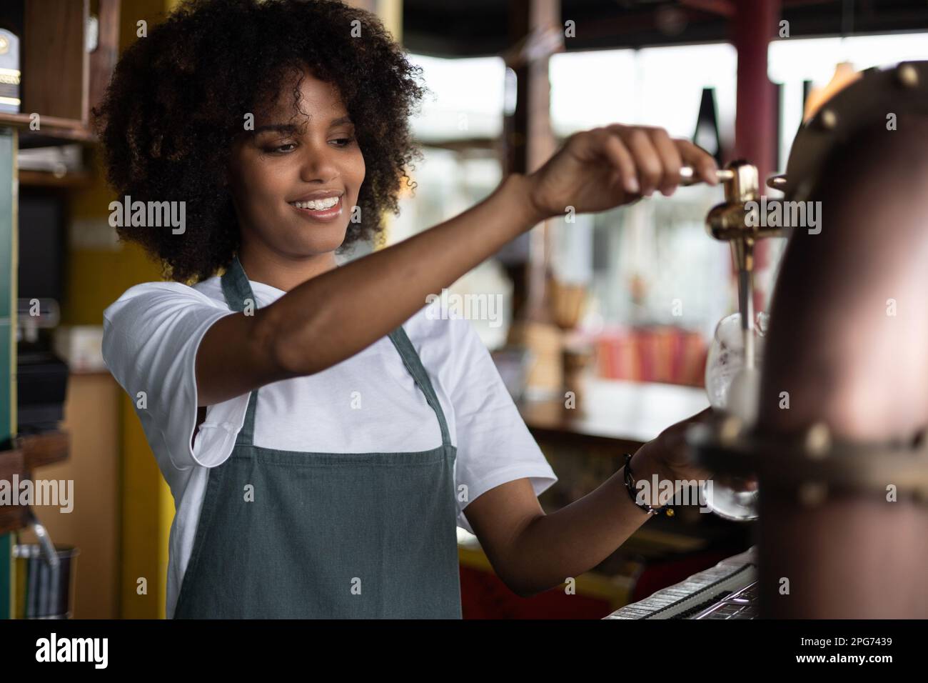 Beautiful African waitress woman serving beer Stock Photo - Alamy