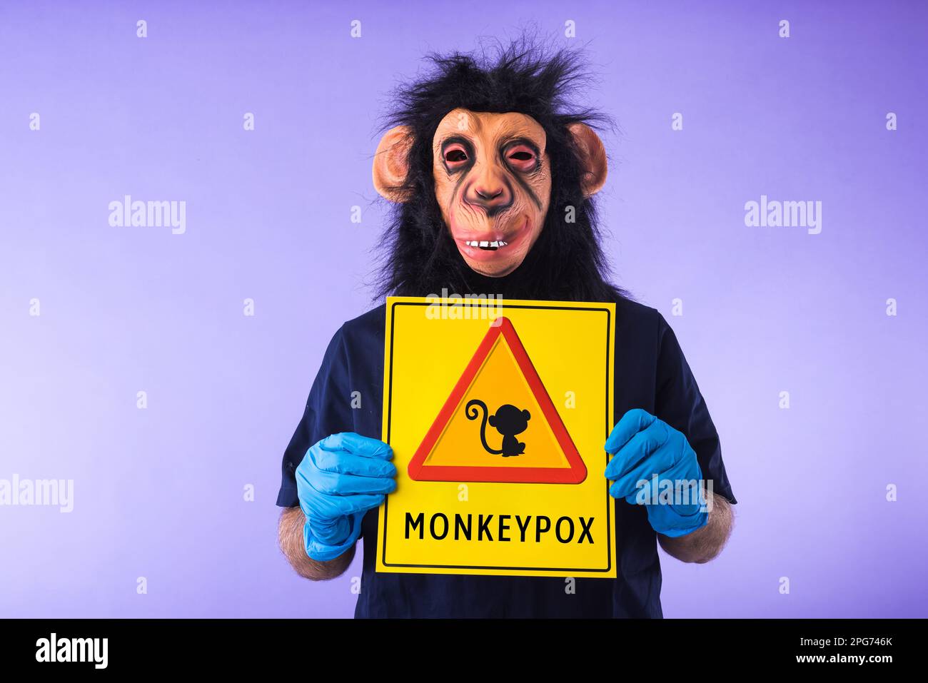 Disguised person with a monkey mask and doctor's suit, holding a sign ...