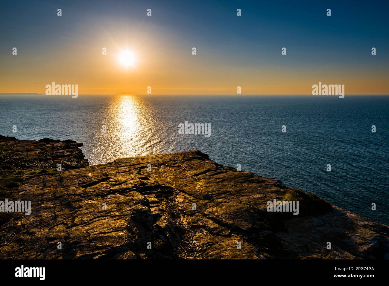 The yellow setting sun at dusk, from Glebe Cliff, Tintagel, Cornwall ...
