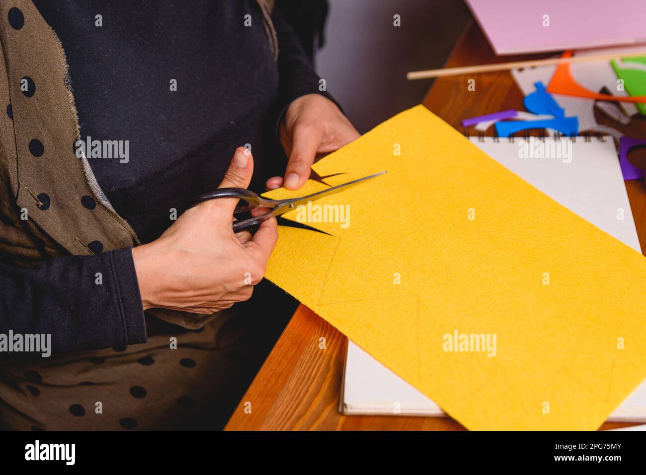 close up of hands with scissors making homemade scrapbooking album from ...