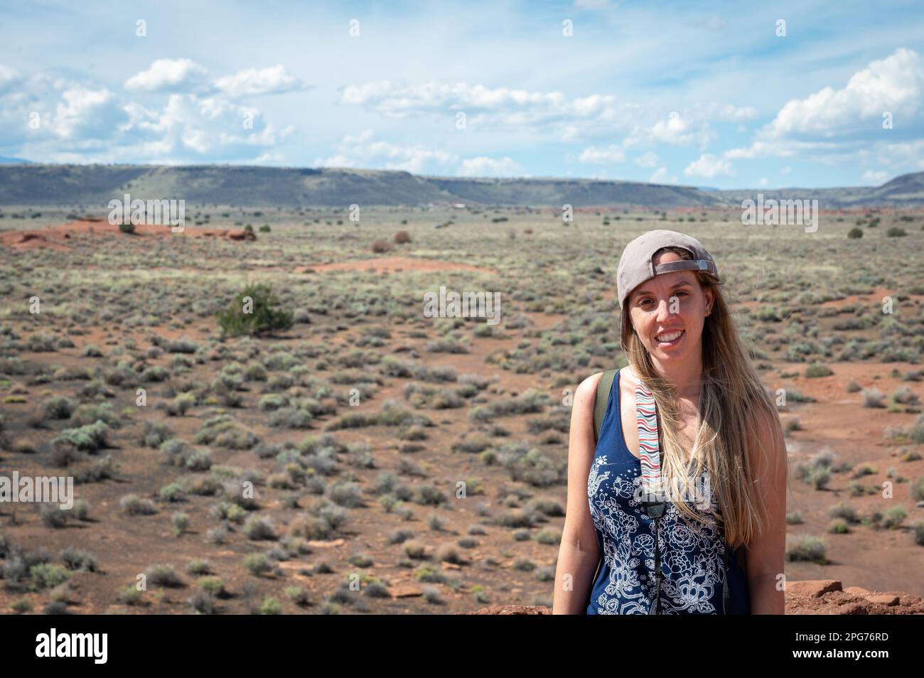 Portrait of a smiling long-haired blonde young girl with backwards cap ...