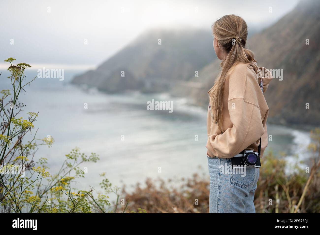 Portrait of a young girl on the cliff of the coastal landscape, she is ...