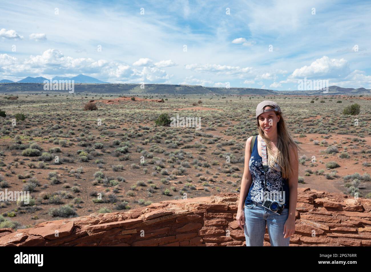 Portrait of a smiling long-haired blonde young girl with backwards cap ...