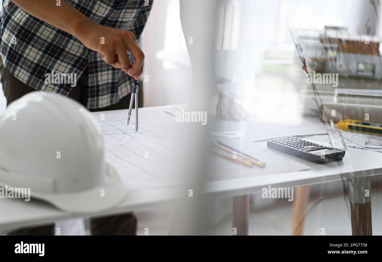 Man hand is using a roundabout to write on a house plan Stock Photo - Alamy