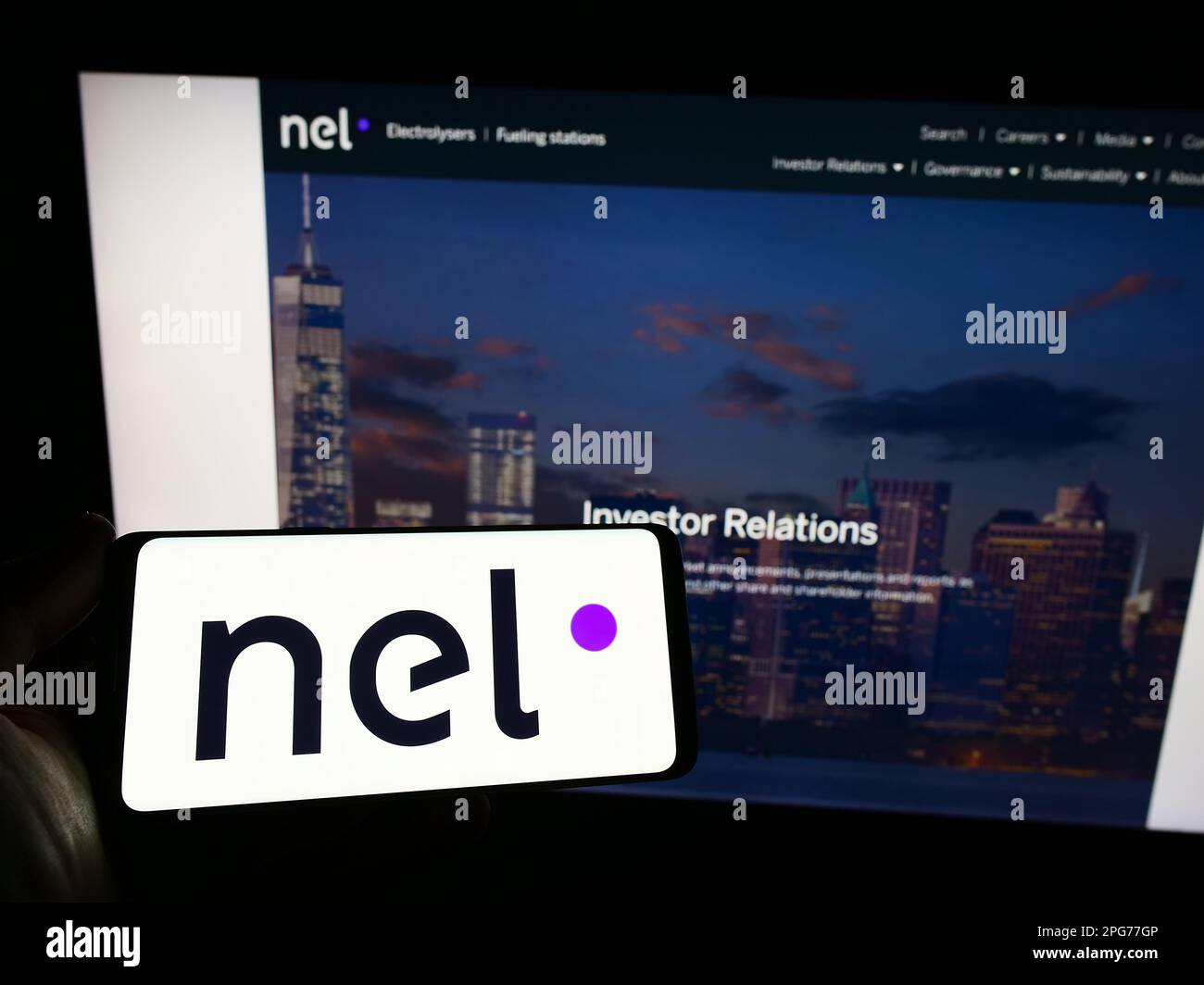 Person holding mobile phone with logo of Norwegian hydrogen company Nel ...